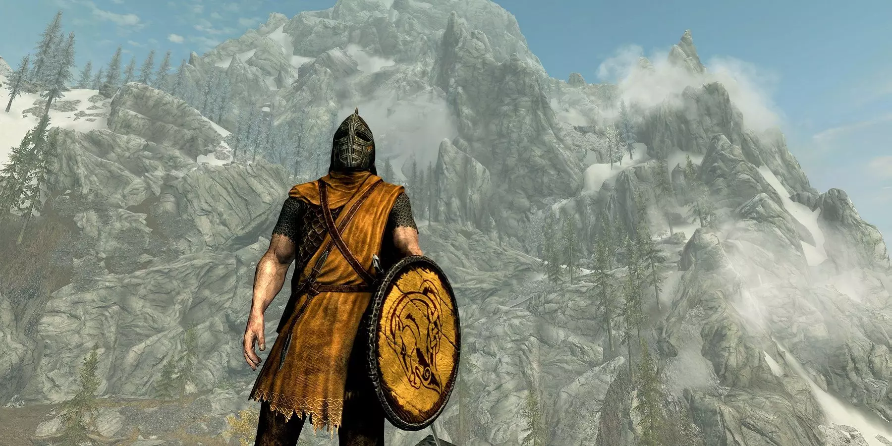 Imazhi nga Skyrim që tregon një roje në plan të parë me malin Gryka e Botës në sfond.