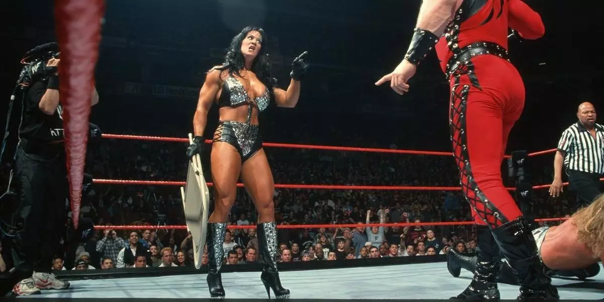 WWE Chyna akiwa ameshika kiti, akimkazia macho Kane