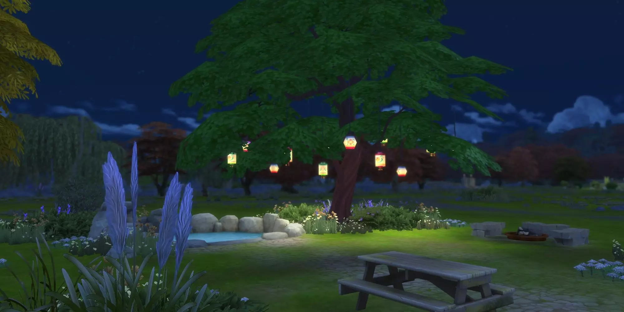 'n Stil piekniekarea in die Sims 4 met 'n groot eikeboom wat saans talle papierlanterns vashou.