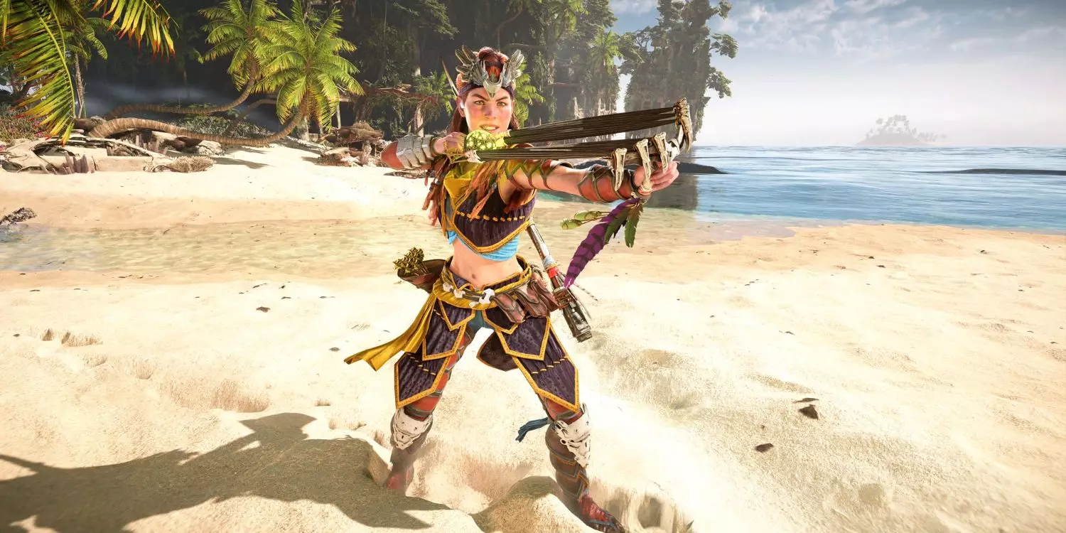 Aloy in einem rot-gelben Outfit an einem Strand, der sich an einer Schlinge zurückzieht, die mit einem grünlichen Ball beladen ist