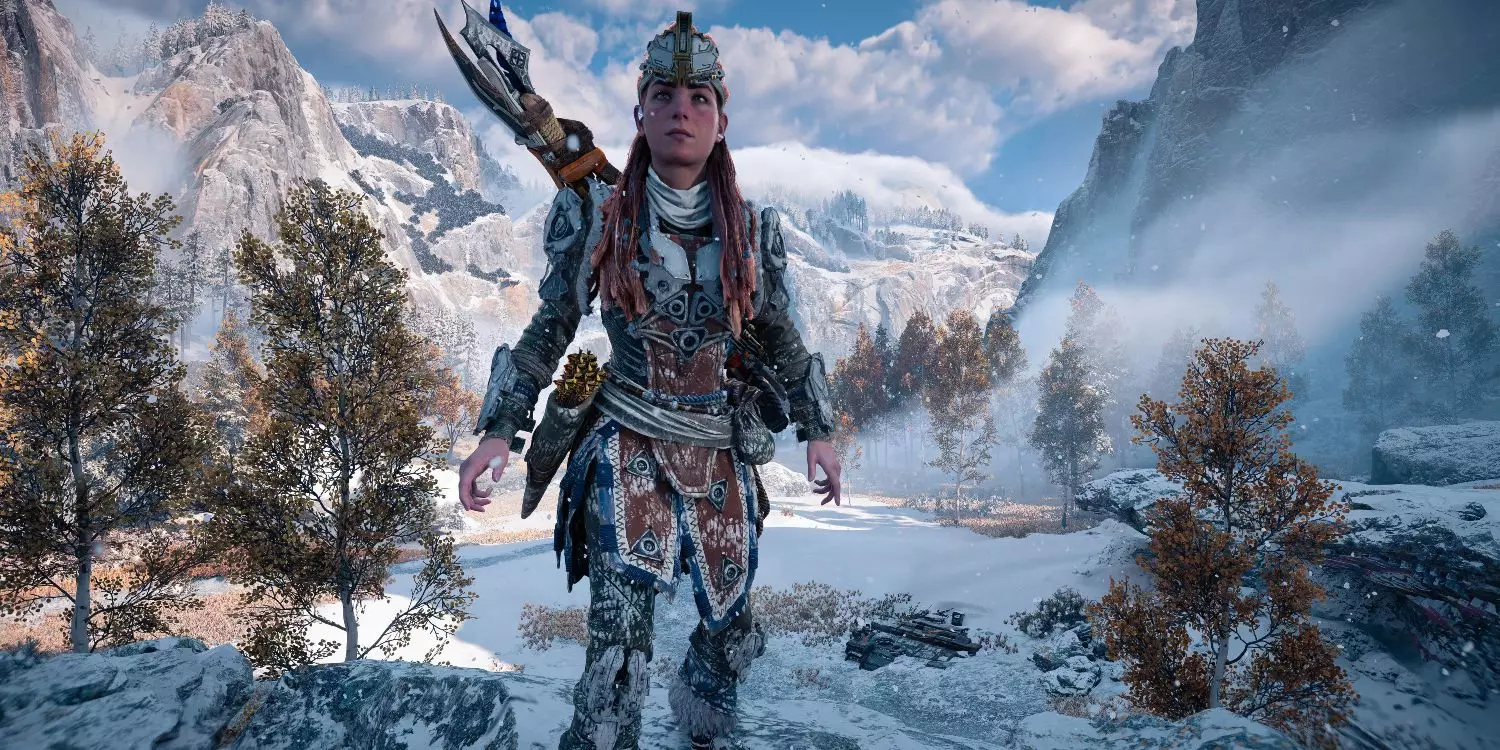 aloy dans une tenue blindée debout dans une vallée enneigée avec des montagnes s'étendant en arrière-plan