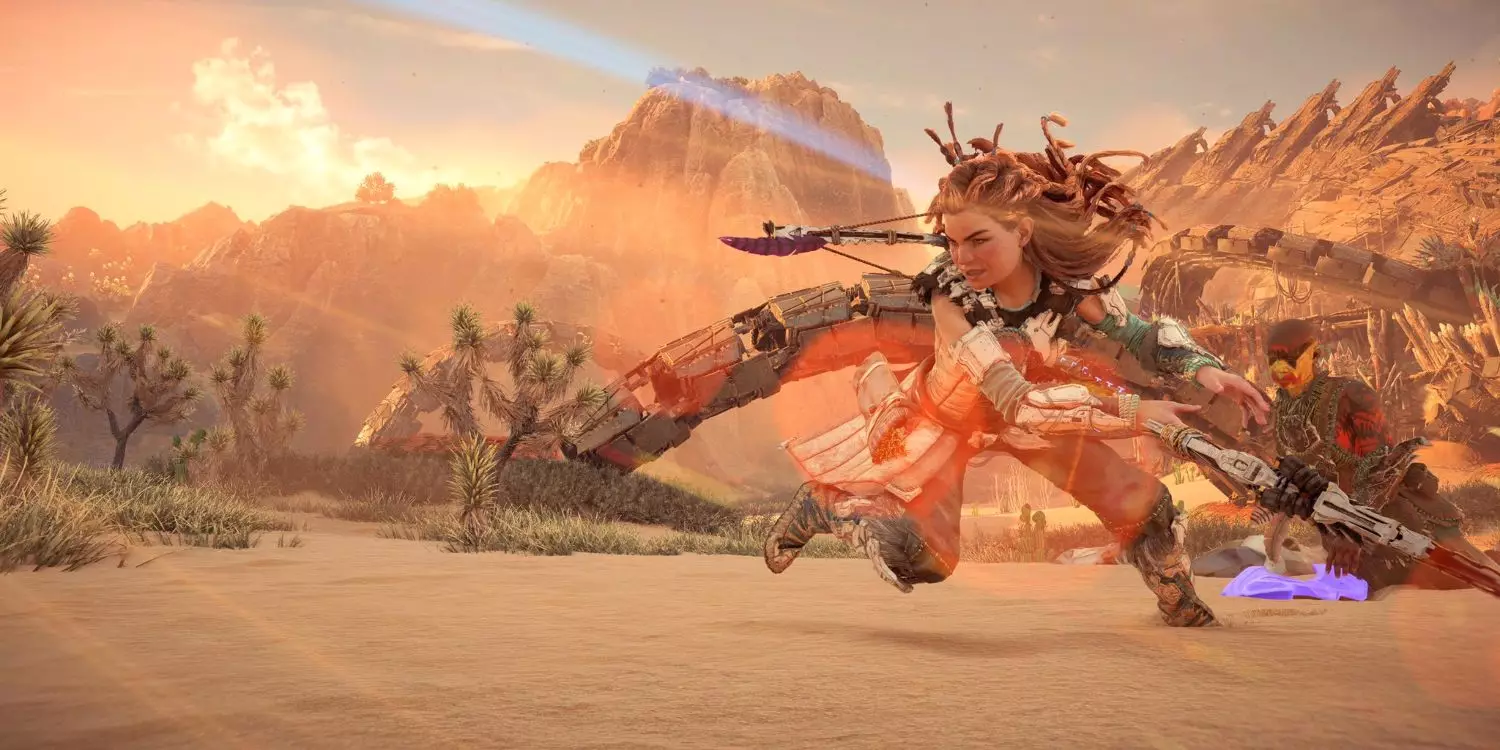 Aloy dempeus en un desert movent la seva llança en un gran arc mentre un soldat enemic s'agenolla a terra darrere d'ella